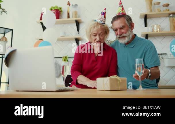 A joyful elderly couple enjoys a virtual celebration filled with ...