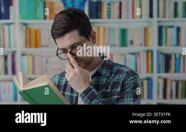 A man, who is wearing a pair of glasses, is currently engaged in ...
