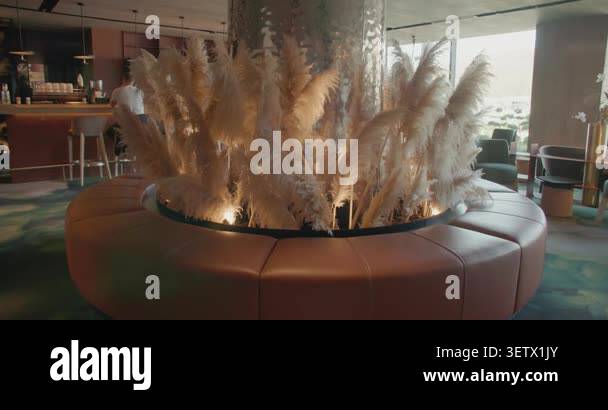 In a stylish restaurant lobby, a man reflects at a cozy bar among ...