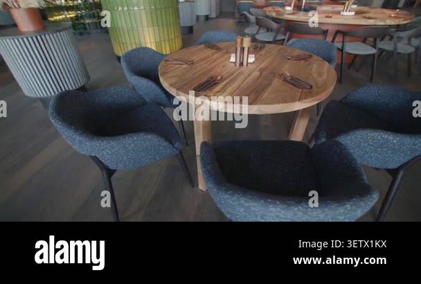 A cozy restaurant with a wooden table and blue chairs, creating an ...