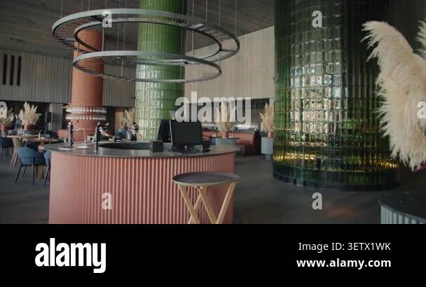 The video highlights a spacious restaurant with a central bar, chairs ...