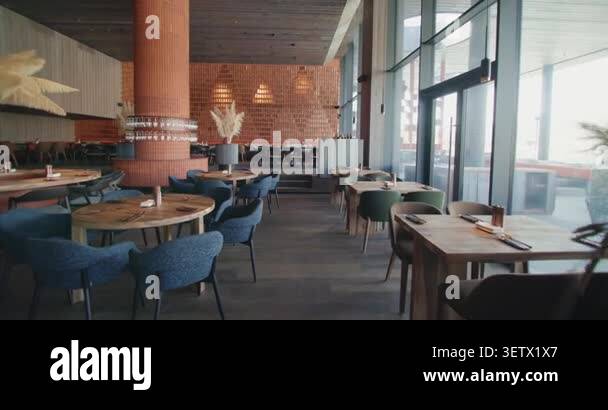 Discover a spacious restaurant with elegant tables, stylish brick walls ...