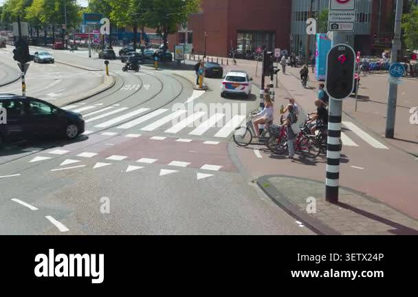 Amsterdam Cars And Cyclists Moving Through City Intersection. High ...