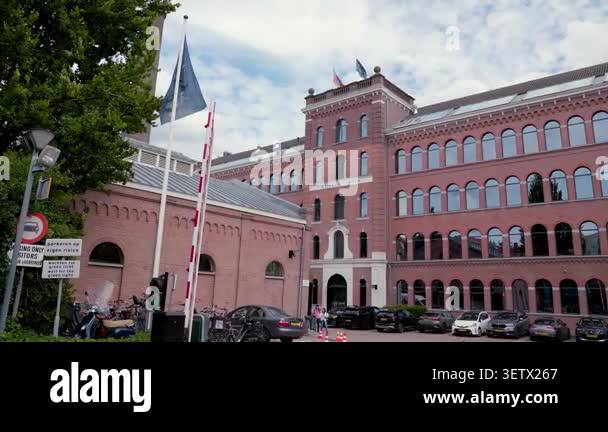 Amsterdam Red Brick Historic Building With Flags And Trees. High ...