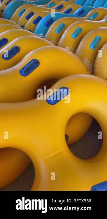 Stack of yellow and blue inflatable swimming tubes at a water park on ...