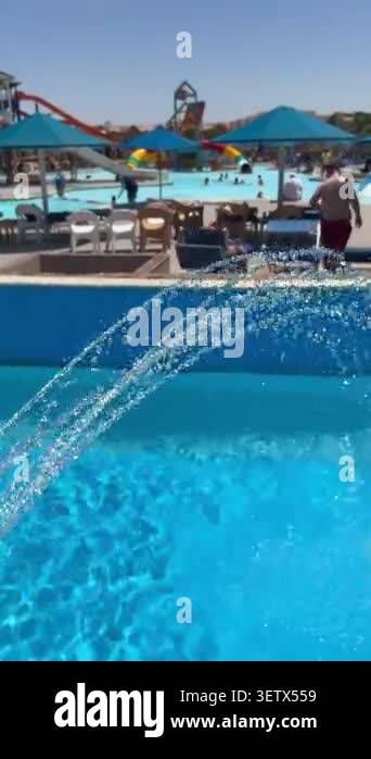 Water fountain spraying a sunny swimming pool with water on June 20 ...