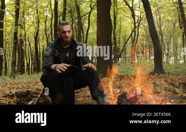 Campfire warmth, hands warming, wilderness fire. Survivalist dressed in ...
