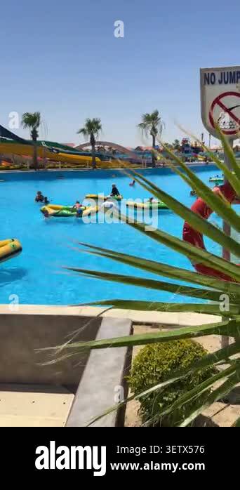 People swimming and floating rafts a bright outdoor water park on June ...