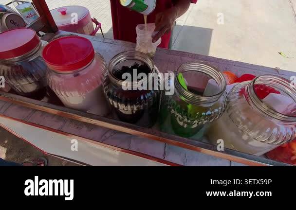 Video of Vendor preparing Fruits soup drinks from glass jars. Bright ...