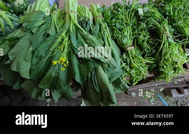 Video of Fresh leafy greens and cabbage displayed on a market stall ...