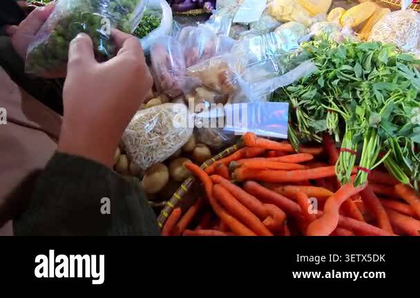 Video of Vibrant vegetables fill a bustling market stall. Hands select ...