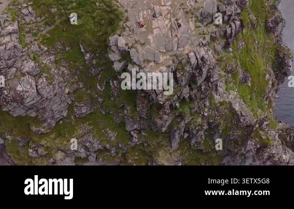 Aerial drone footage of dramatic moss-covered granite cliffs with ...