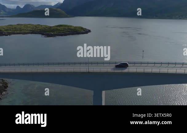 Aerial view of vehicle crossing modern bridge spanning scenic fjord ...