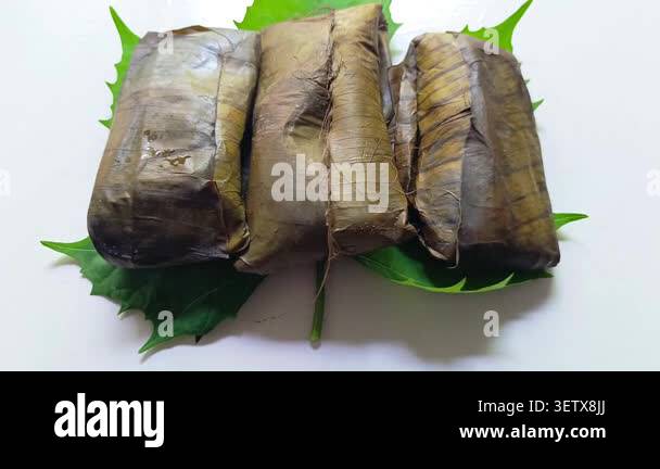 Studio shot of three traditional Guatemalan chaya tamales wrapped in ...