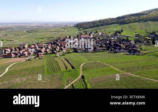 Orbiting aerial drone view circling an Alsace wine village with red ...