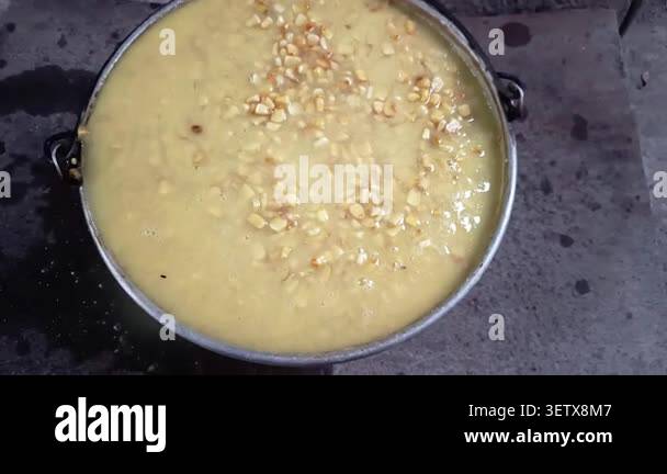 High angle view of white corn kernels boiling in lime water inside a ...