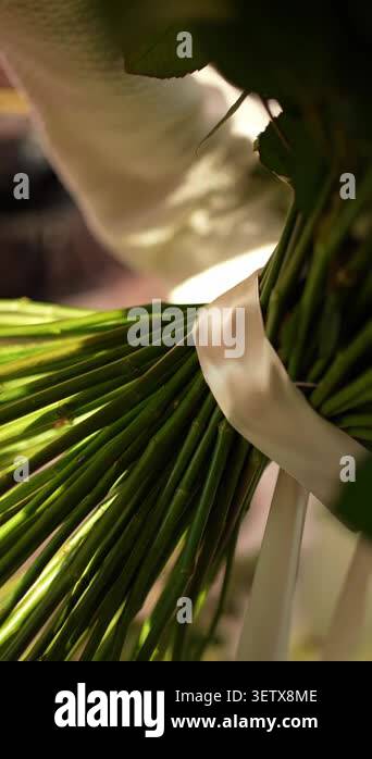 Florist ties a bouquet of flowers with satin ribbon, flower arrangement ...