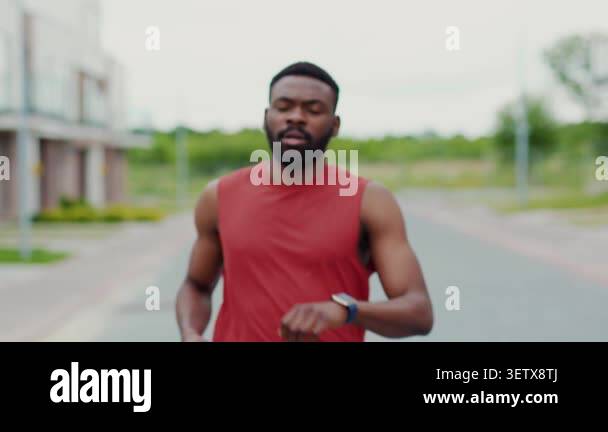 The video showcases urban determination as a man in a red tank top runs ...