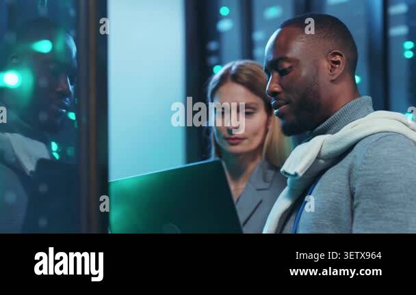 In a hightech server room, a man and woman discuss and analyze data on ...