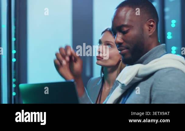 A man and woman discuss while examining a laptop, sharing ideas in a ...