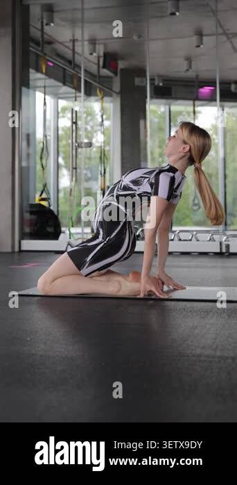 Athletic young woman performing the ustrasana yoga pose for back ...
