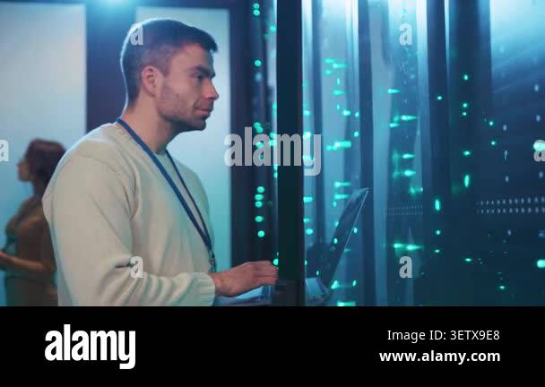 An IT professional in a data center monitors network performance ...
