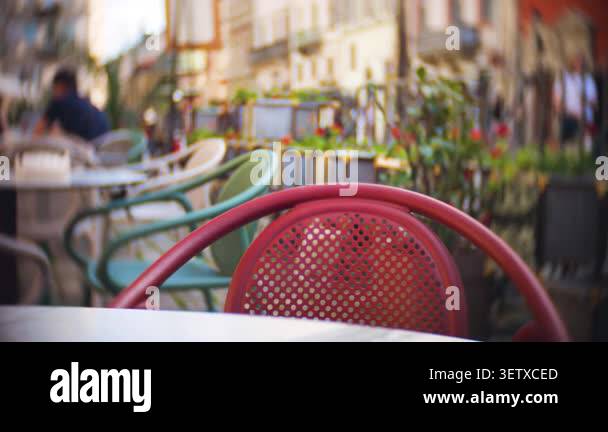 Cozy outdoor cafe terrace with colorful chairs on a sunny summer day ...