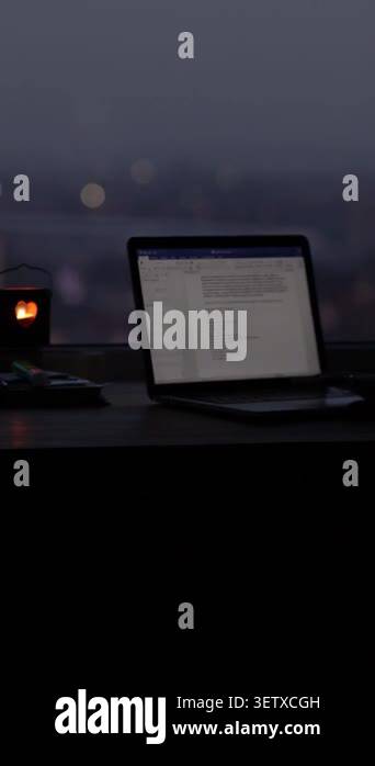 Laptop with stock charts on desk at night window. Vertical layout of ...