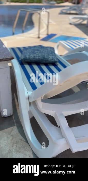Sunbed with a patterned cushion by a blue swimming pool at a on June 20 ...