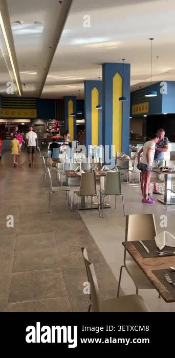 Modern hotel restaurant dining hall with blue and yellow pillars on ...