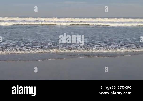 Peaceful coastal landscape featuring layers of rolling white sea foam ...