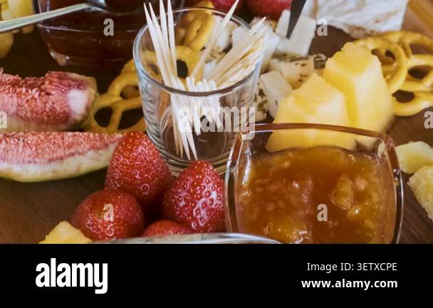 Assorted cheese platter with fresh figs, strawberries, nuts, pretzels ...