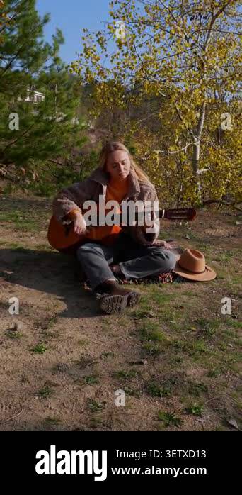 Portrait of smiling caucasian artist plays wooden acoustic guitar in ...