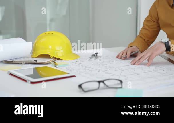 Engineers hands sketching and annotating architectural blueprints on a ...