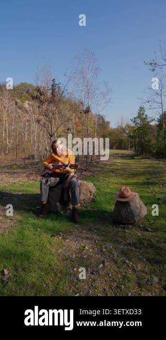 Portrait of smiling caucasian artist plays wooden acoustic guitar in ...