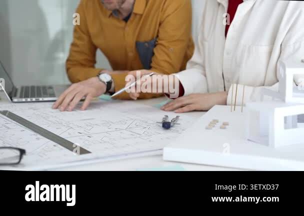 Architects hands working on blueprints and architectural models ...