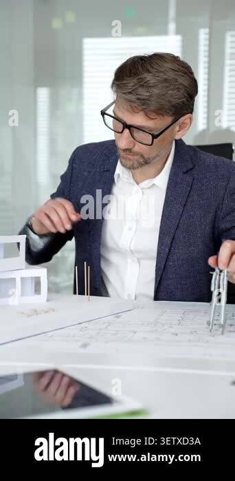 Architect carefully planning new real estate structure, using drafting ...