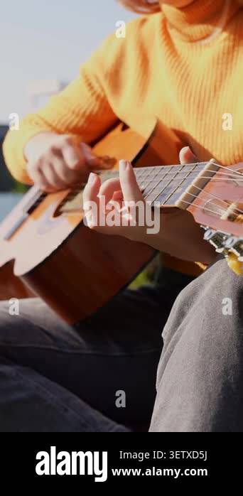 Close up of hands artist plays wooden acoustic guitar in autumnal park ...