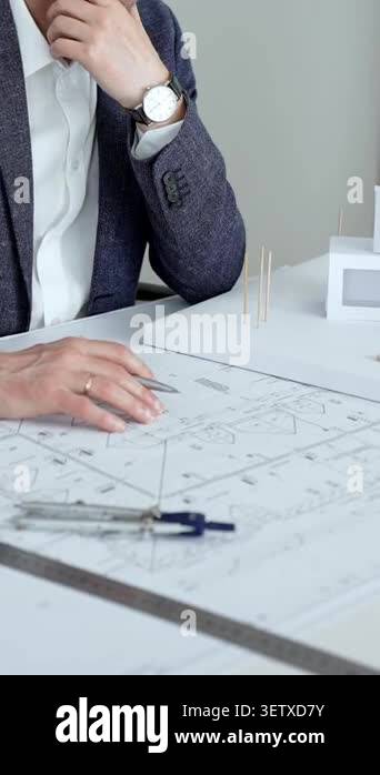 Architect drawing and studying building plans and blueprints ...