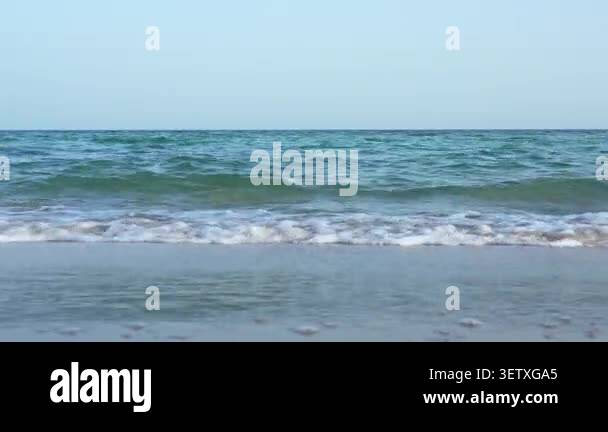 Eye level static shot of clear turquoise ocean water and waves crashing ...