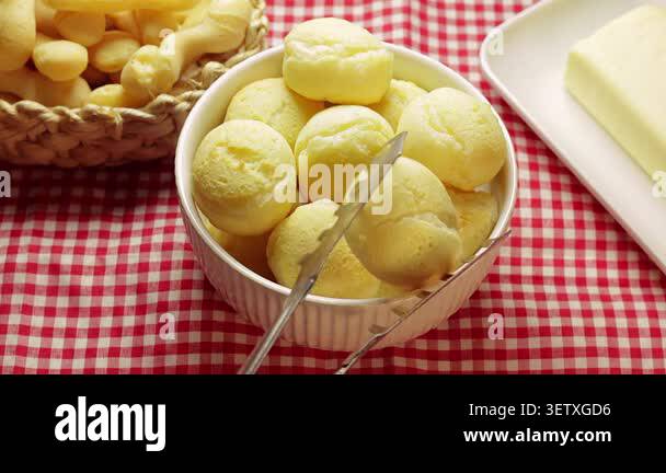 Authentic Brazilian cheese bread being removed from a white ceramic ...