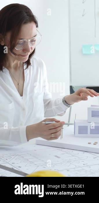 Woman architect actively developing a concept model for a new building ...