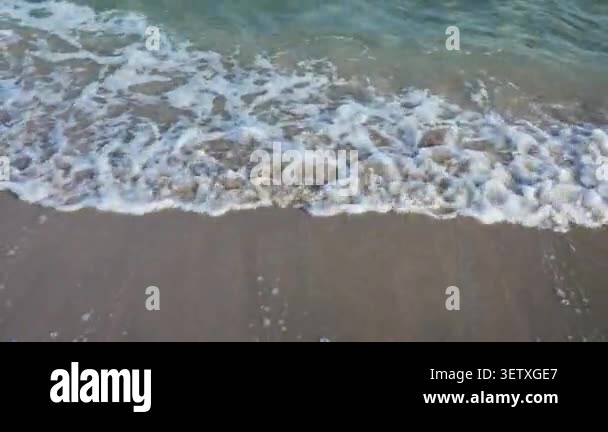 High angle steady shot of clear turquoise ocean waves and sea foam ...