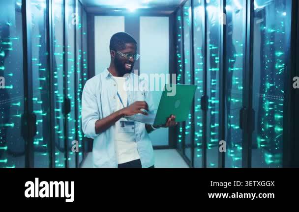 A focused man navigates a hightech server room with multiple servers ...
