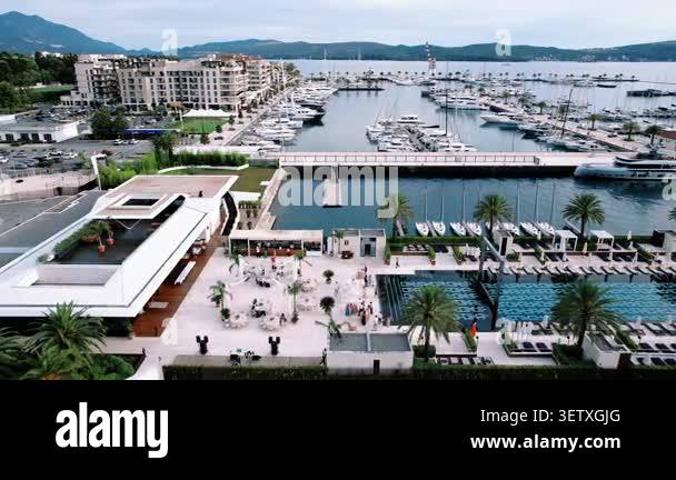 Aerial marina Porto Montenegro pool terrace showing guests, palm trees ...