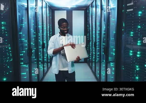 A professional evaluates a server rooms systems, analyzing data on a ...