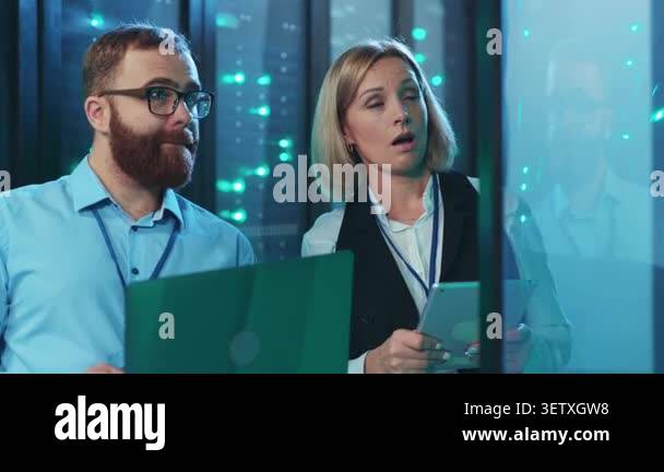 In a hightech server room, a man and woman intently analyze data on a ...