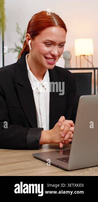 Young businesswoman at home office joins video call on laptop wearing ...