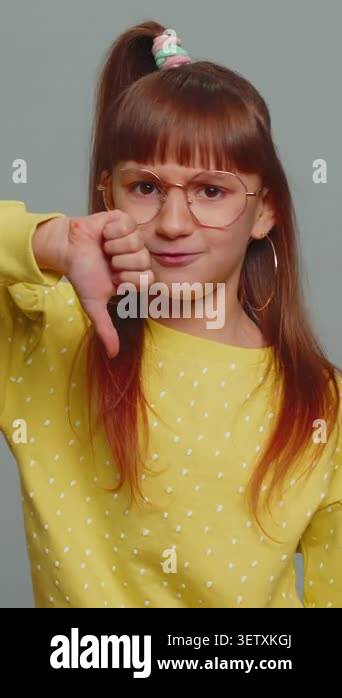 Dislike. Upset young preteen child girl kid showing thumbs down sign ...