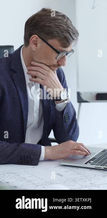Architect or engineer working on a construction project, using a laptop ...